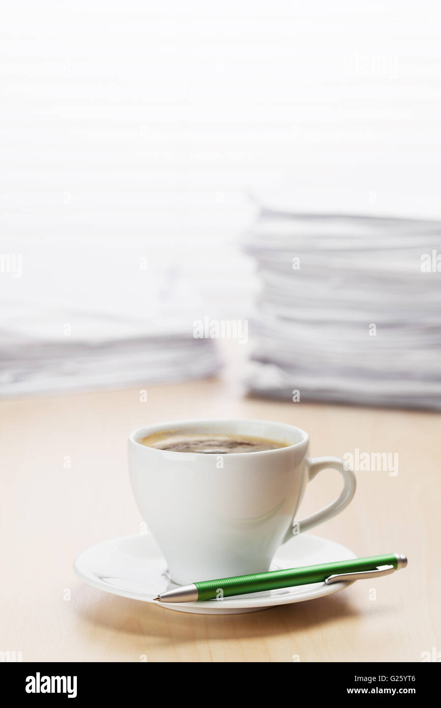 Office workplace with coffee cup and lot of documents on wood desk ...