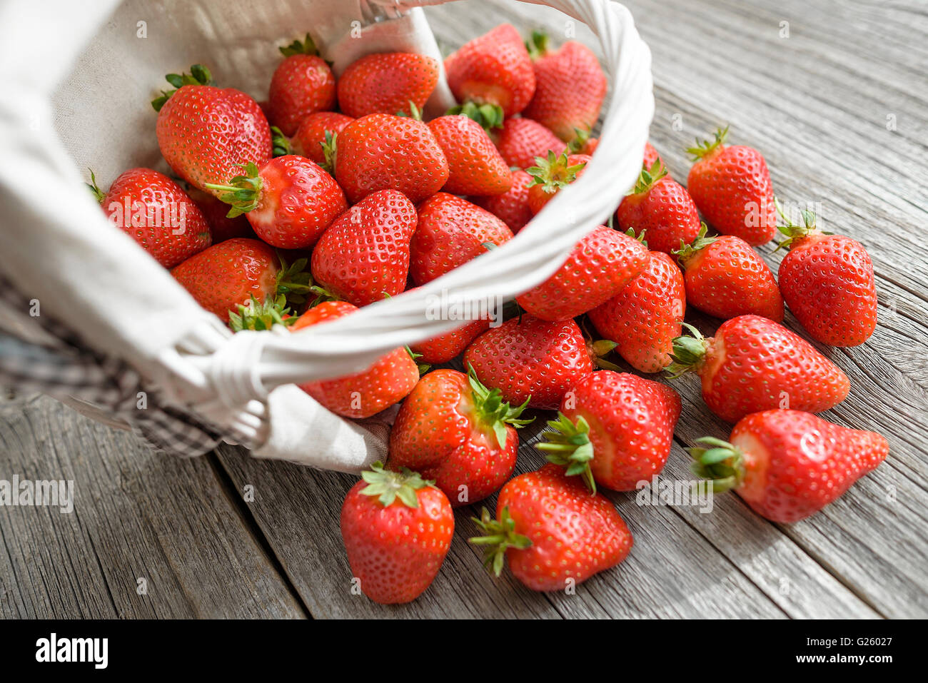 Strawberry dropped out of the basket on wooden boards Stock Photo - Alamy