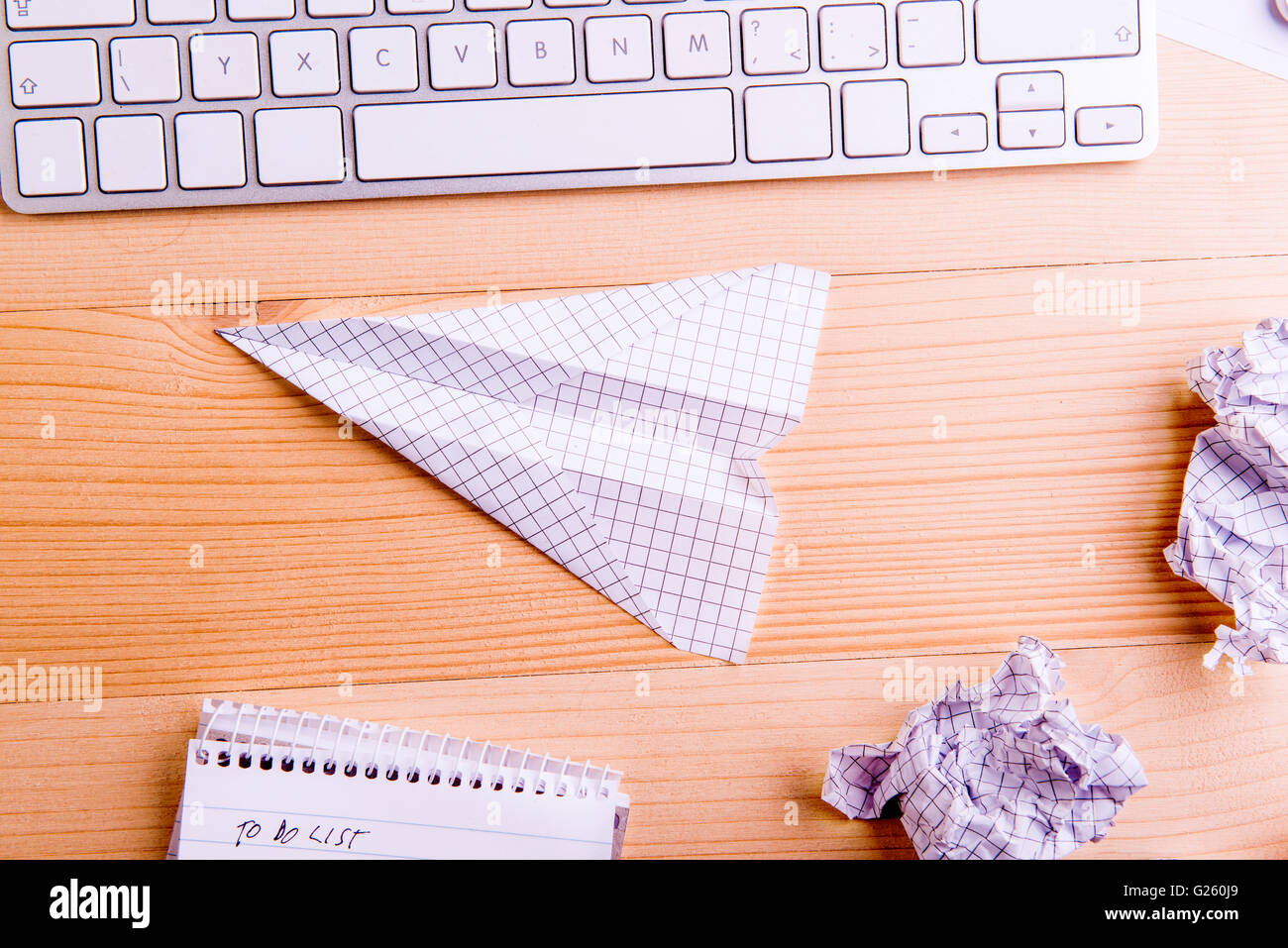 Office desk, paper airplane. Studio shot, wooden background Stock Photo ...