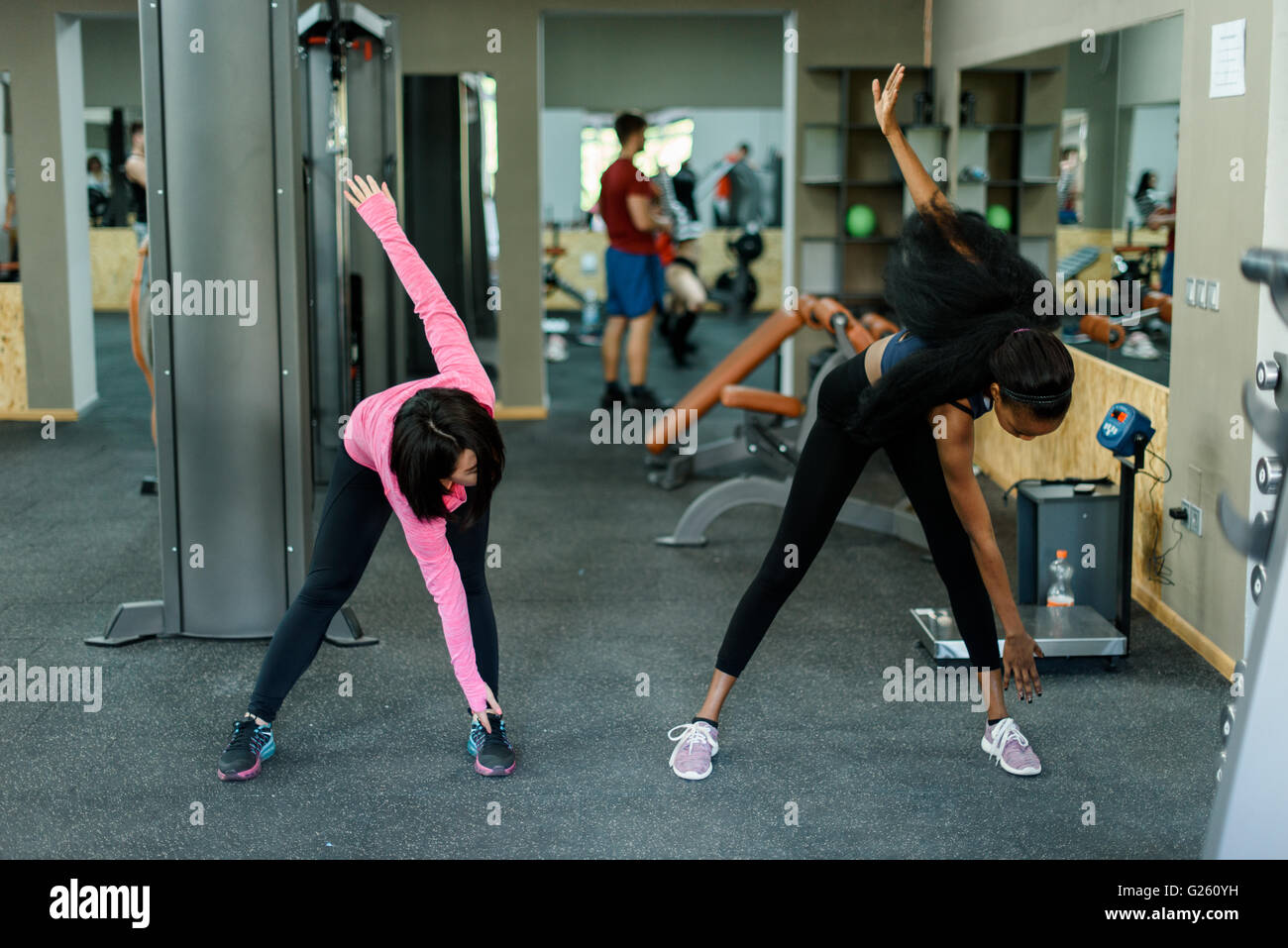 Slim black african-american fitness instructor shows to asian lovely ...