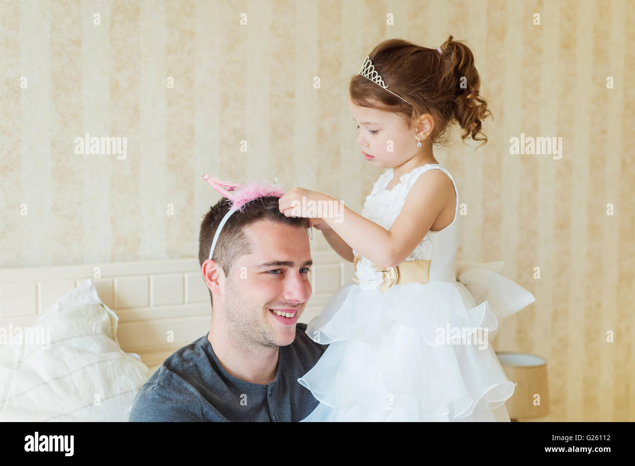 Cute girl putting a crown on her father head Stock Photo - Alamy