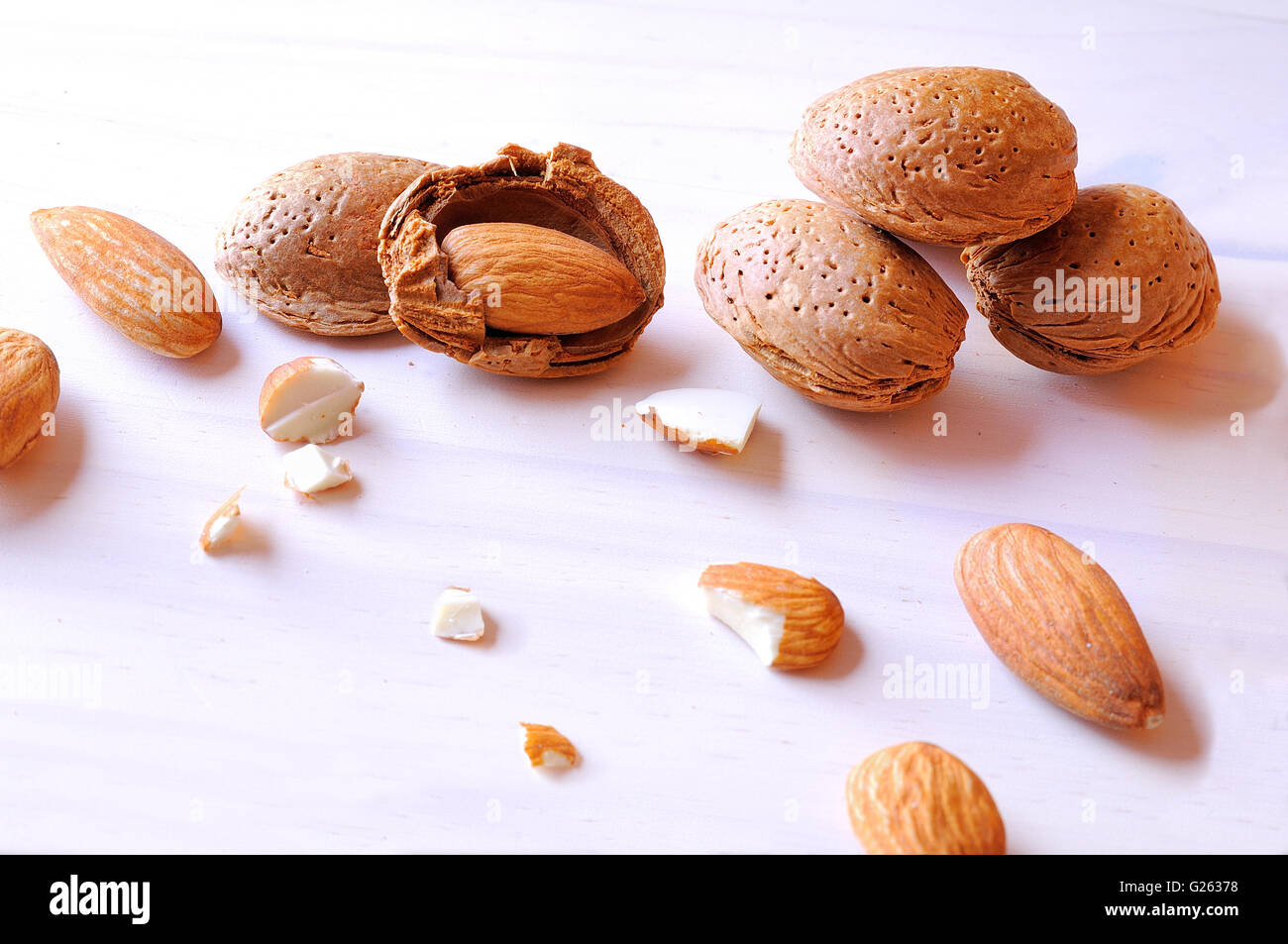 Group of almonds on a white wooden table top view Stock Photo - Alamy