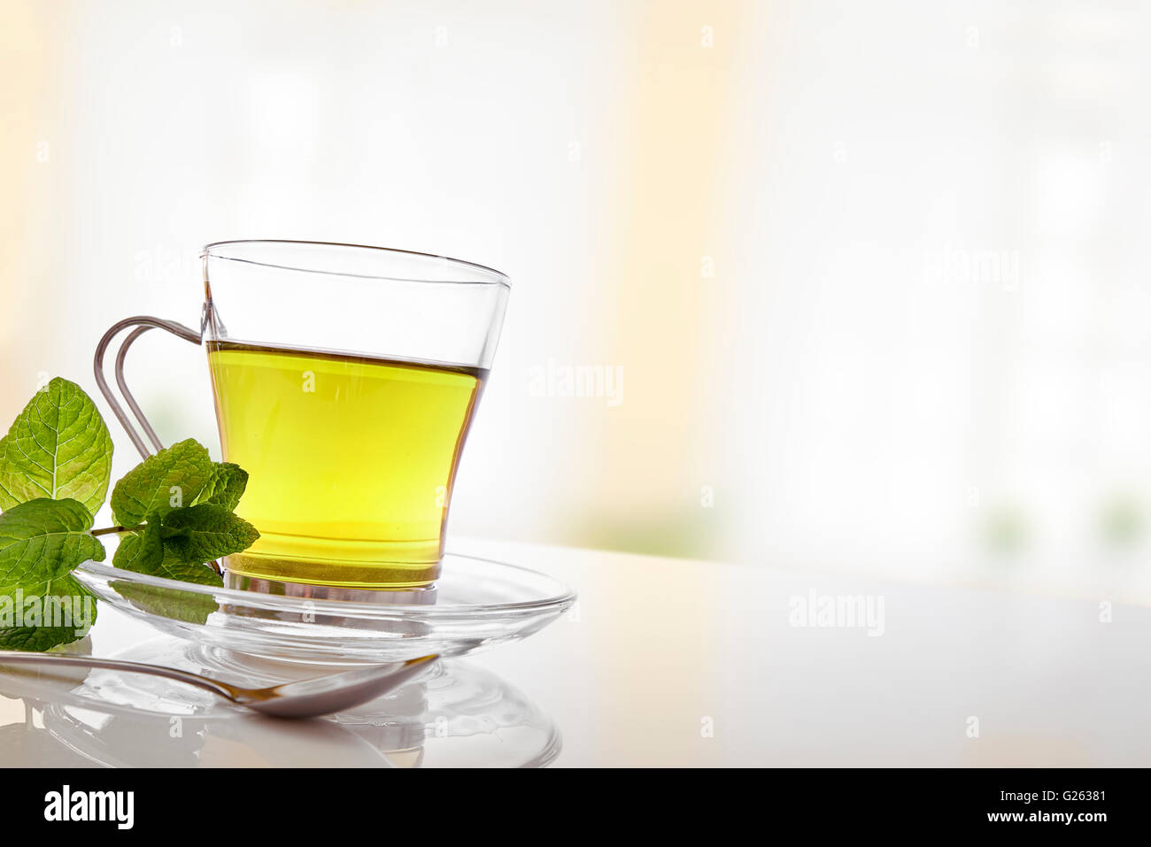 Glass cup green tea with mint on a table in the living room. Horizontal ...