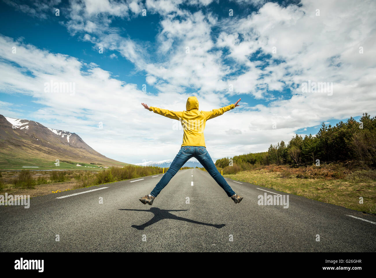Woman jumping on a beautiful road Stock Photo - Alamy