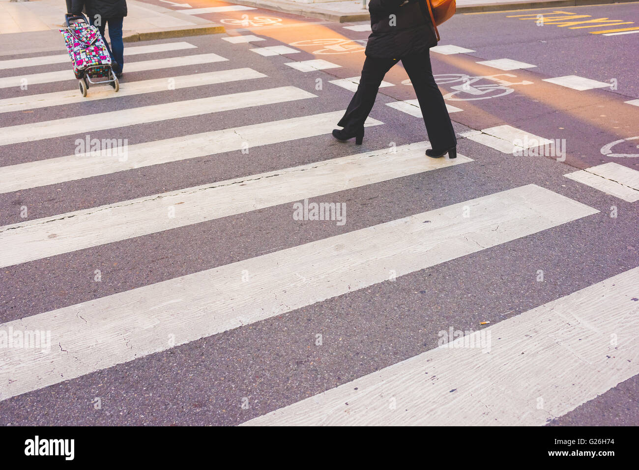 Pedestrian crossing sing with people walking on it Stock Photo - Alamy
