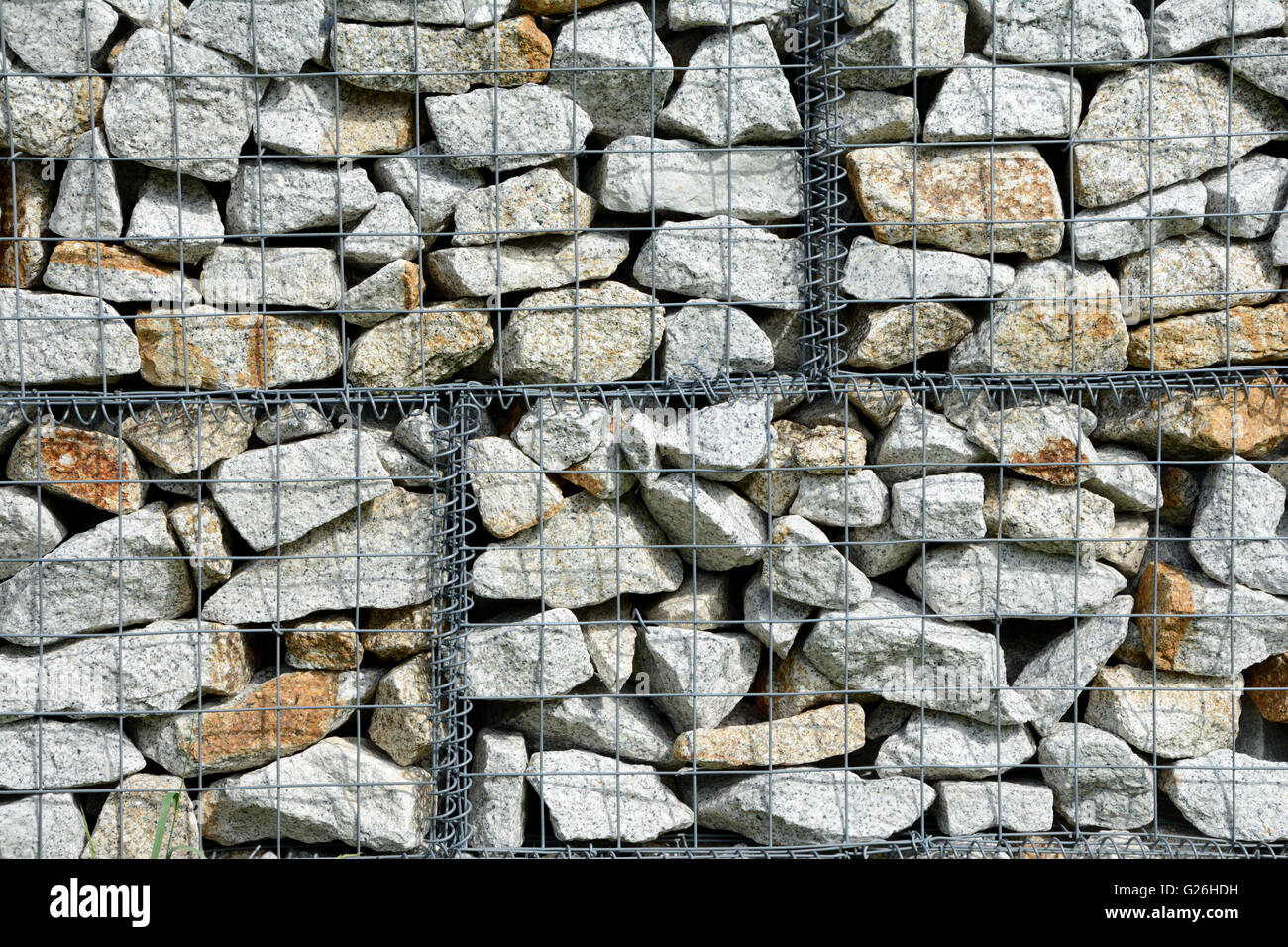 Wall made of stones in wire net - background Stock Photo - Alamy
