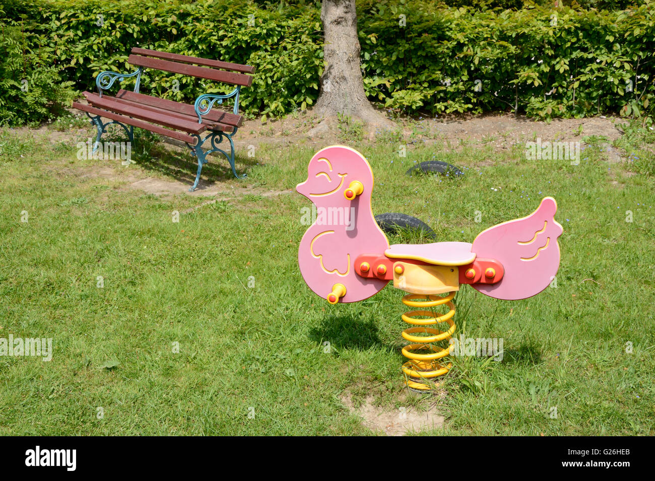 Pink toy and bench on playground in park Stock Photo - Alamy