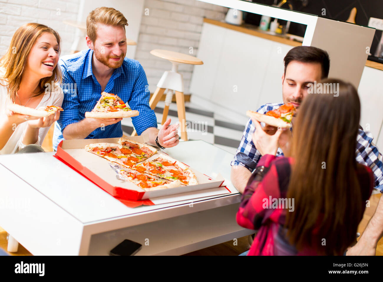 Group of friends eating pizza together at home Stock Photo - Alamy