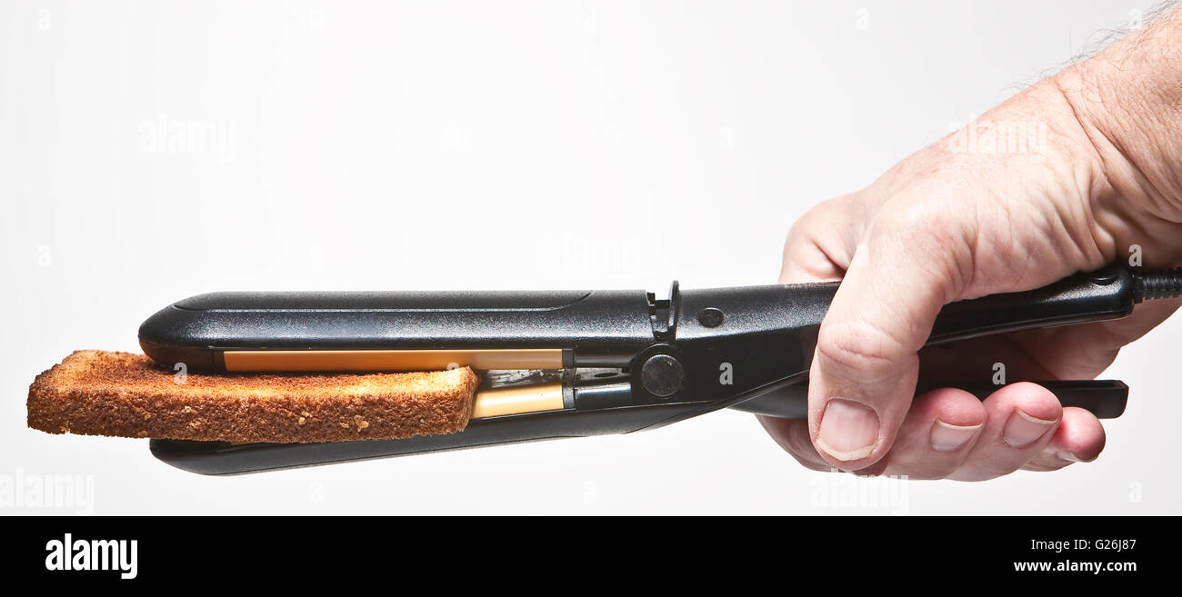 Male hand holding hair straightener holding wheat toast Stock Photo - Alamy