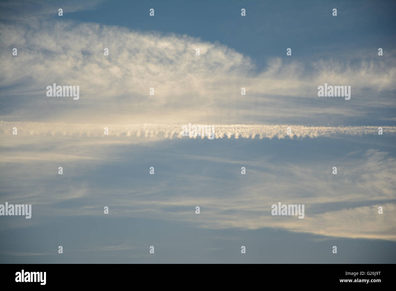 Cirrus clouds, dark blue sky and unique shape contrail in the late ...