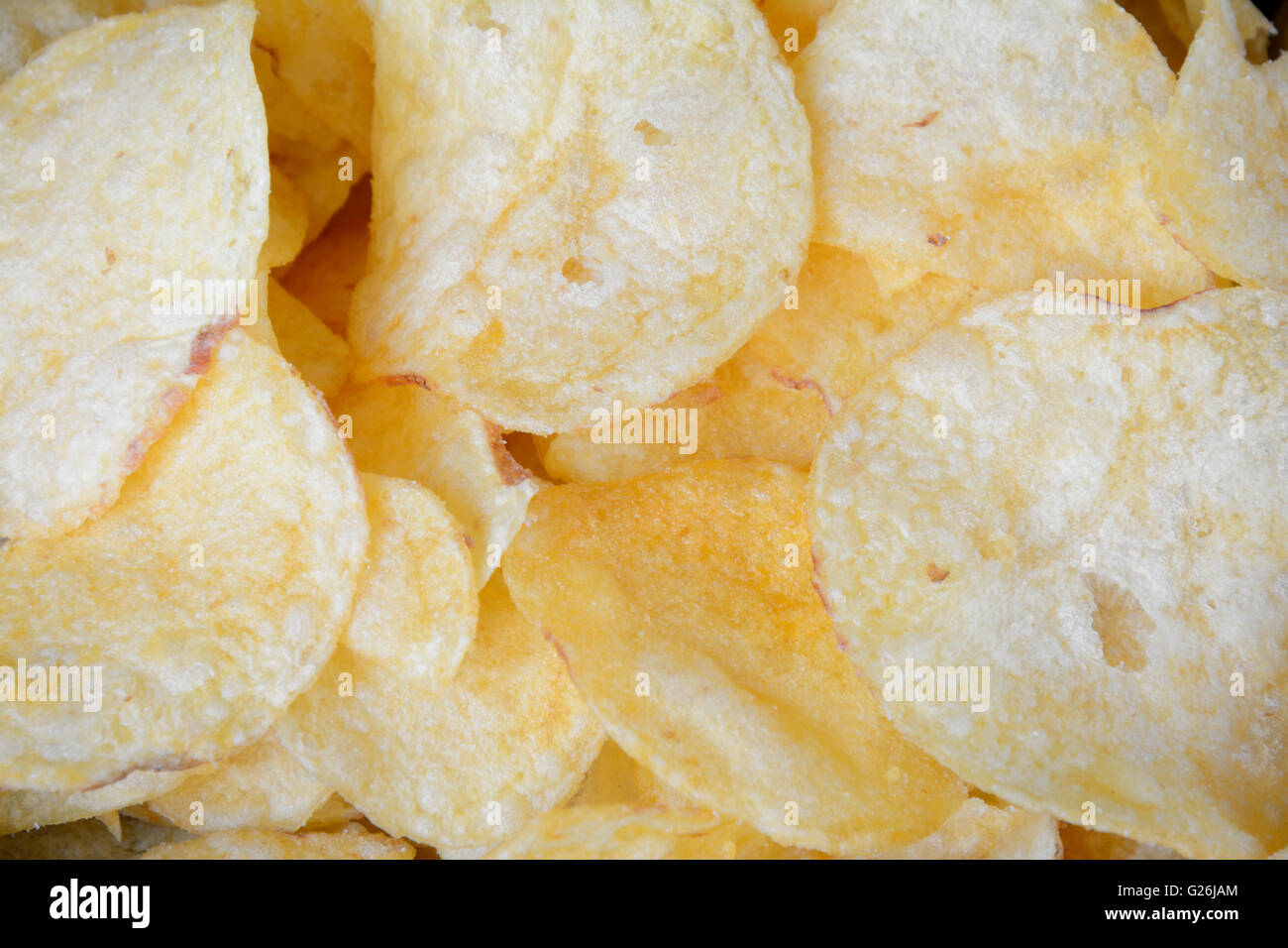 Golden potato crisps closeup - background Stock Photo - Alamy