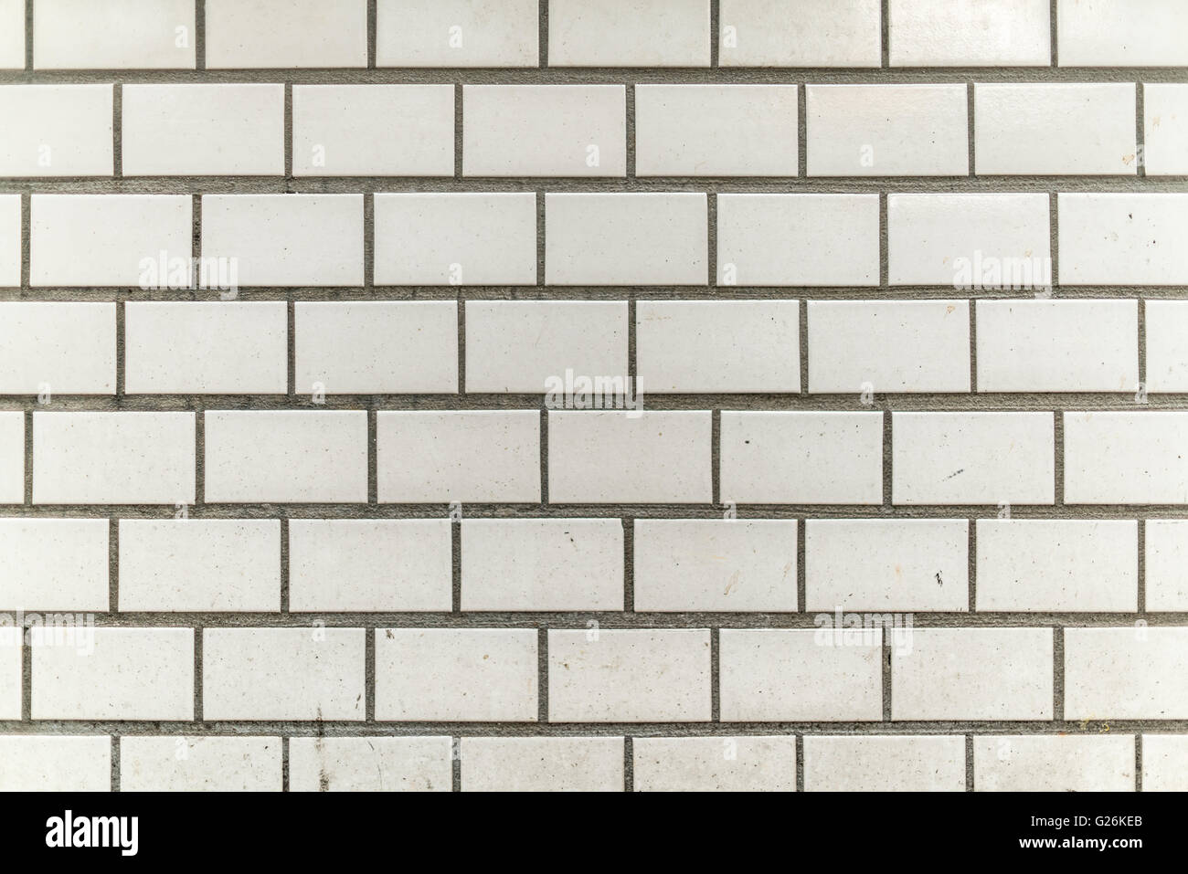 dirty and grainy white grey tile city wall with splashes of dirt and ...