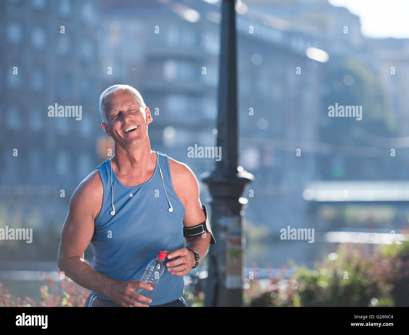 portrait of handsome senior jogging man while relaxing and take break ...