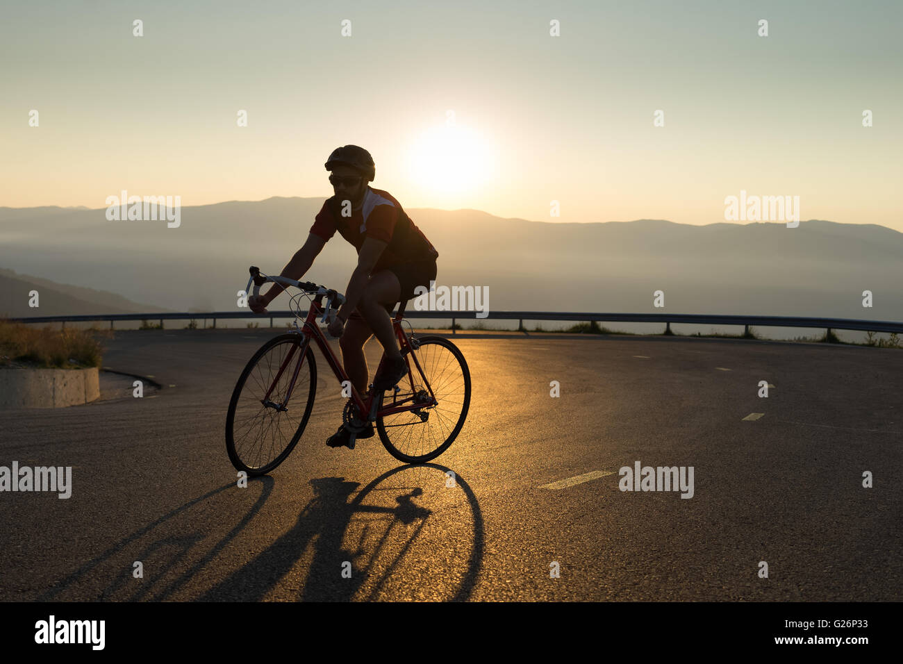 professional cyclist rides his bike up the hill on the asphalt Stock ...