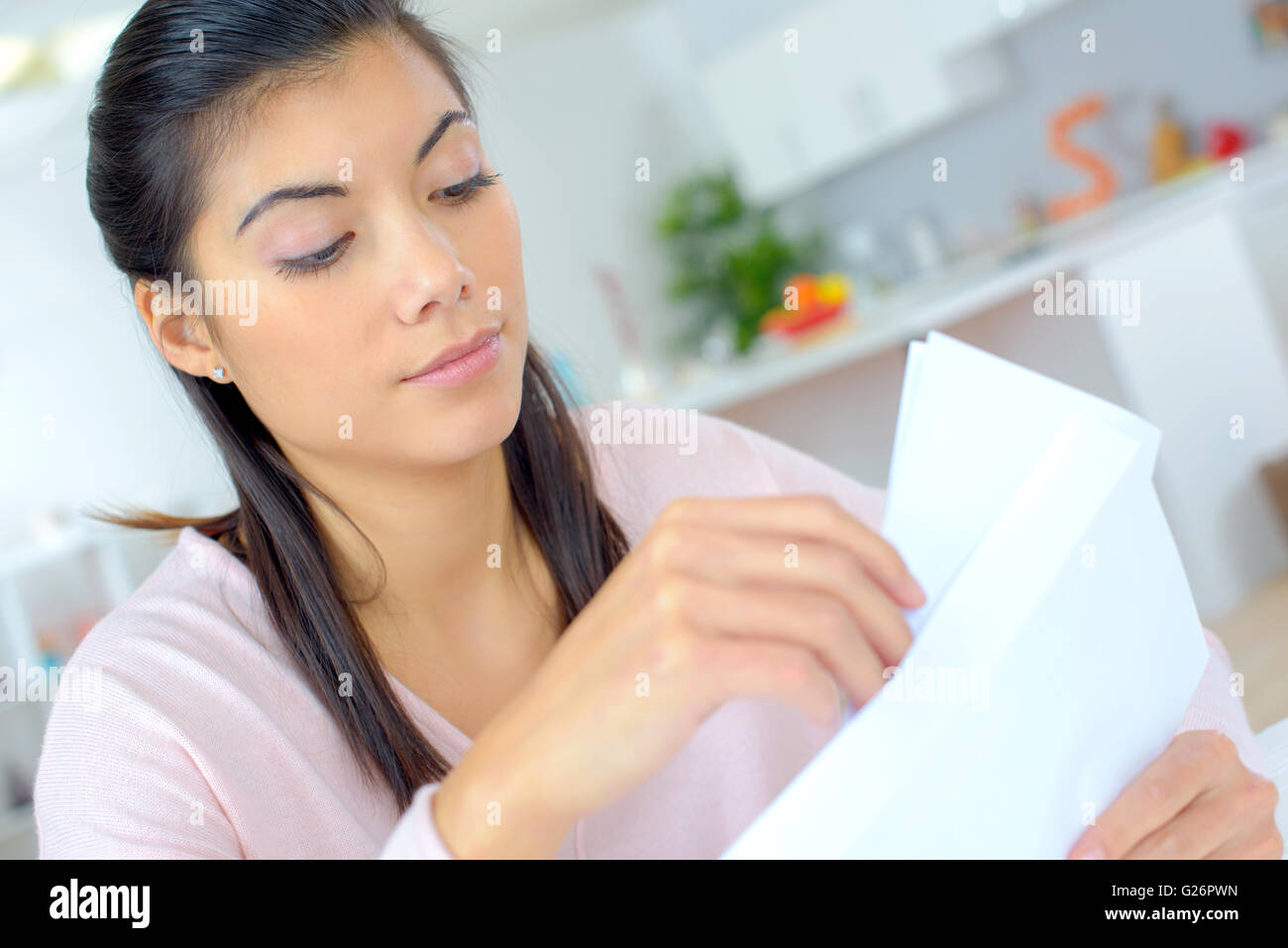 Woman reading a document at home Stock Photo - Alamy