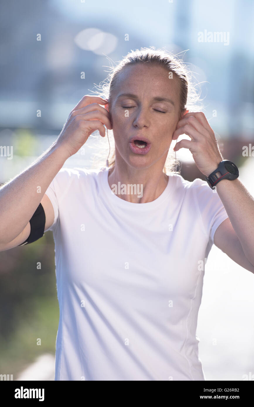 jogging woman setting music and running route on smart phone putting ...