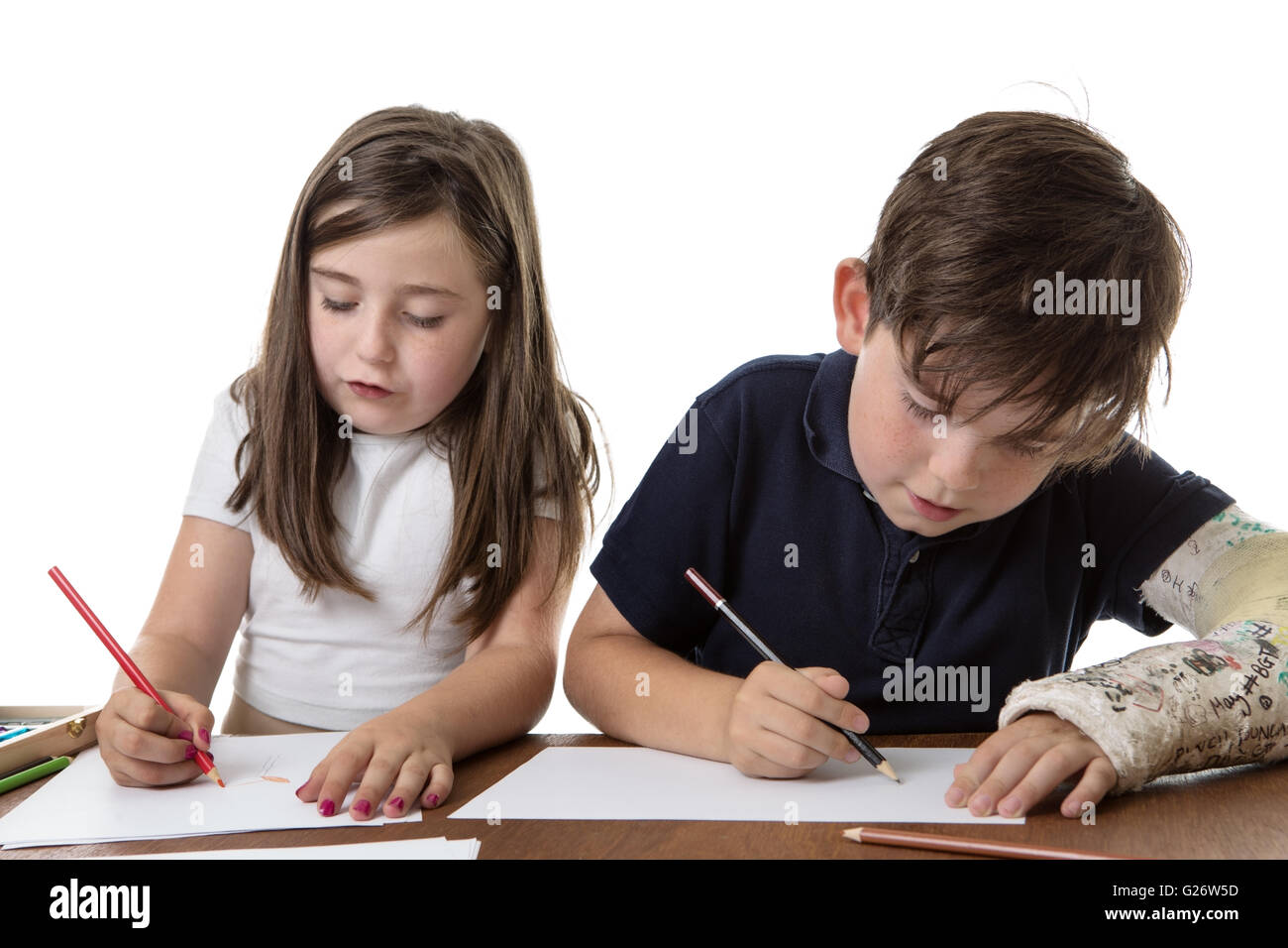 Two children sitting next to each other drawing Stock Photo - Alamy