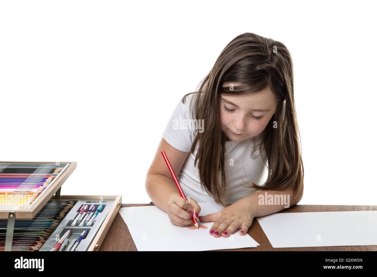 Cute young girl concentrating hard drawing a picture Stock Photo - Alamy