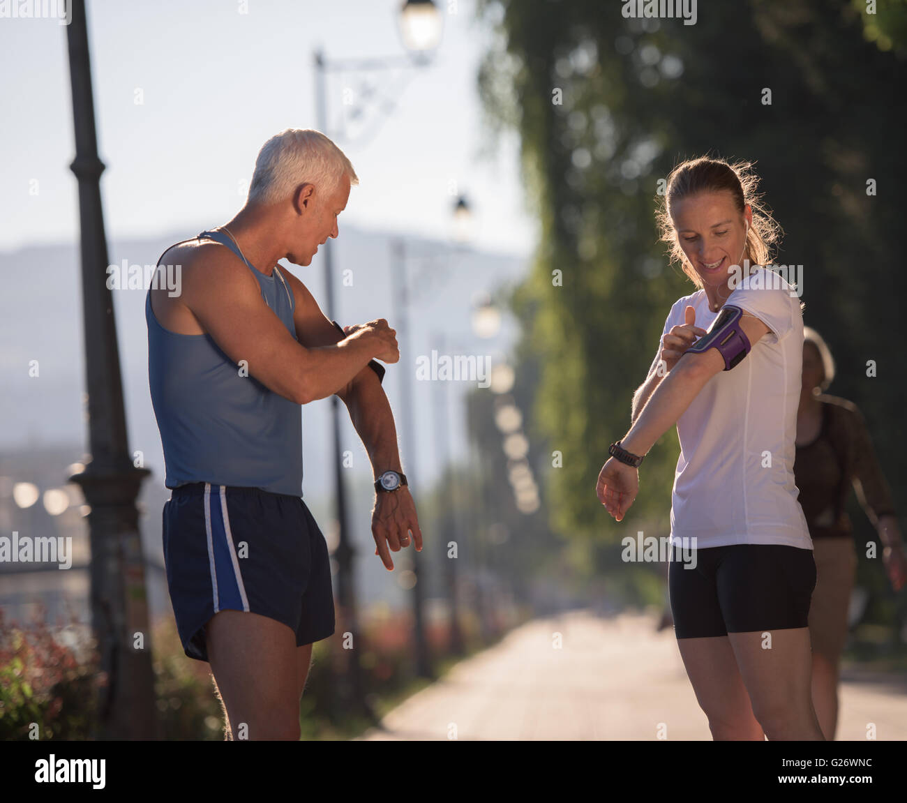 jogging couple check music playlist on phone and plan route before ...