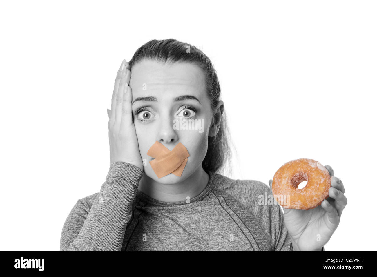 woman with first aid plaster over mouth unable to eat a donut Stock ...