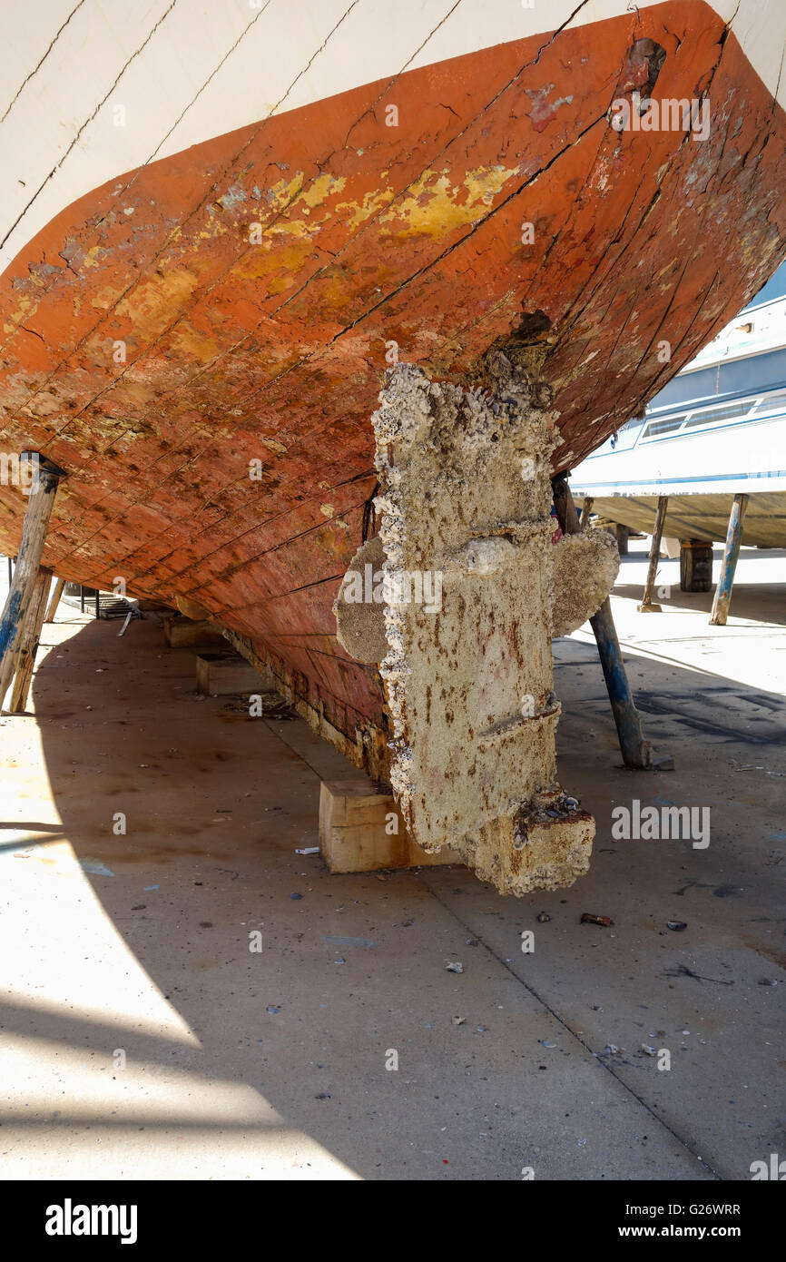 Helm, rudder of old wooden boat in dry dock, boat yard, covered with ...