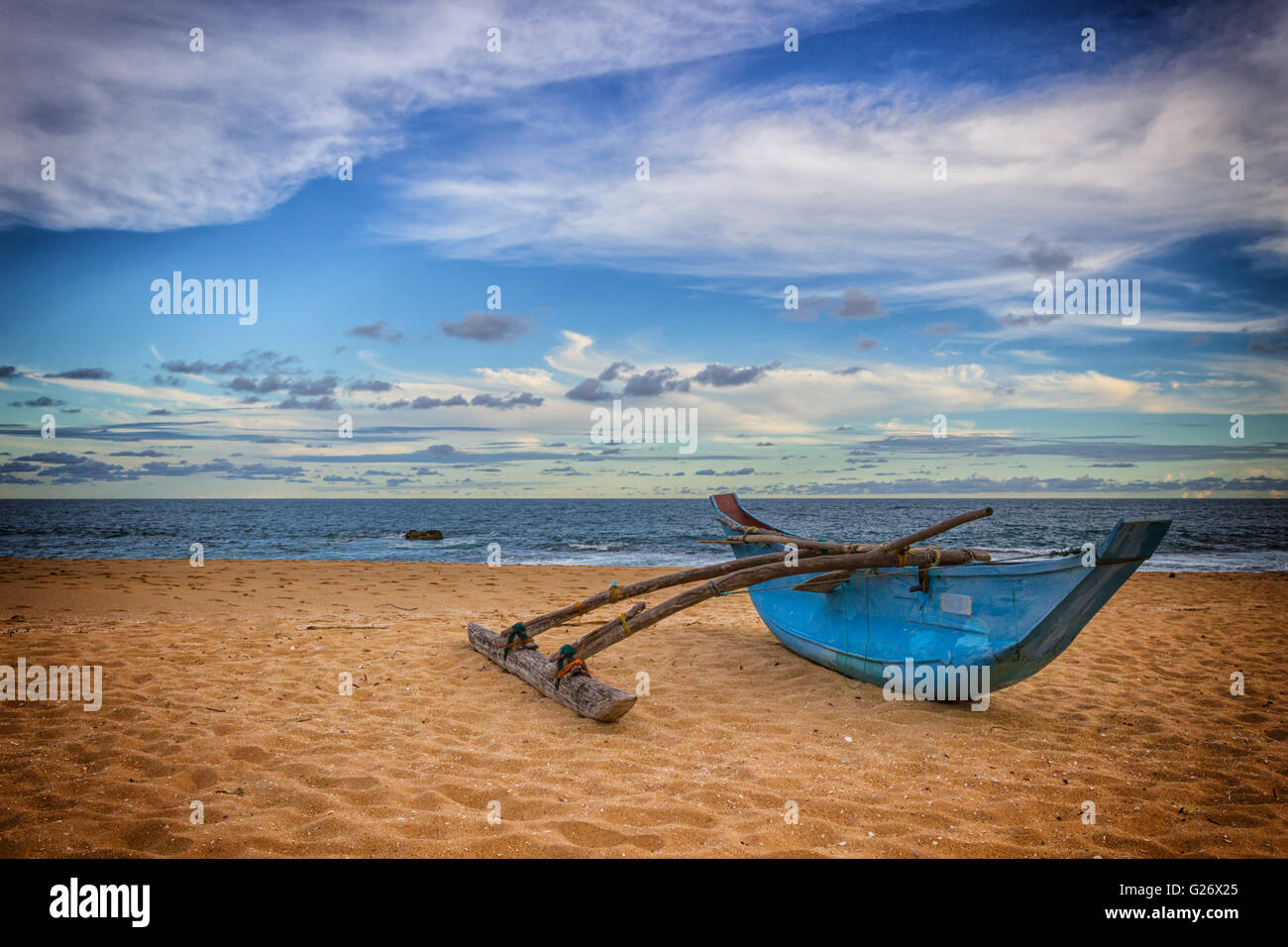 Old blue fishing boat on sandy beach in dramatic light Stock Photo - Alamy