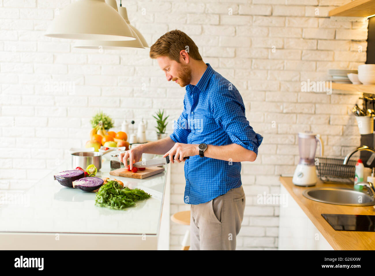 Young man chopping vegetables in the kitchen Stock Photo - Alamy