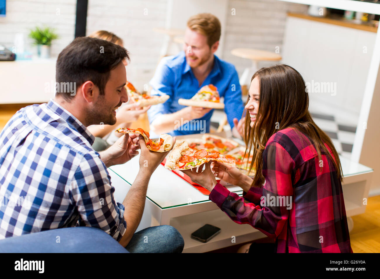 Group of friends eating pizza together at home Stock Photo - Alamy