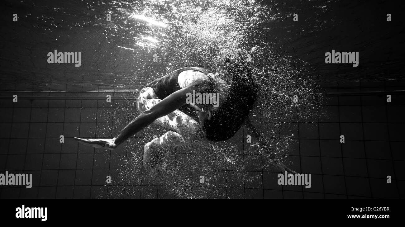 Athletic swimmer doing a somersault underwater Stock Photo - Alamy