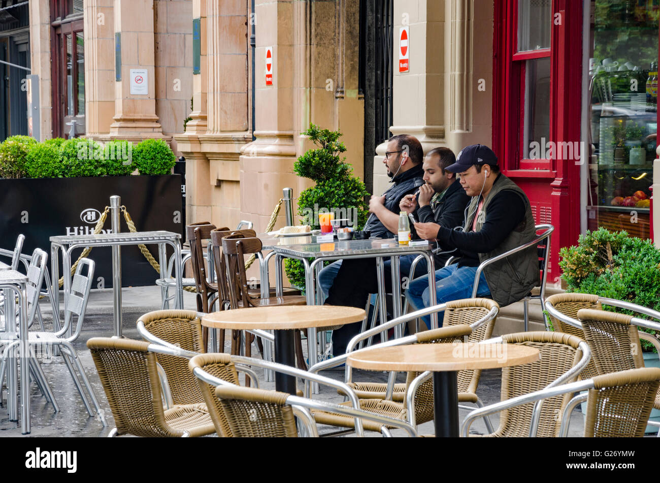 Three men sit outside a cafe with drinks Stock Photo - Alamy