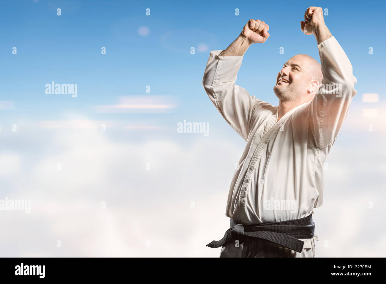 Composite image of fighter posing after victory Stock Photo - Alamy