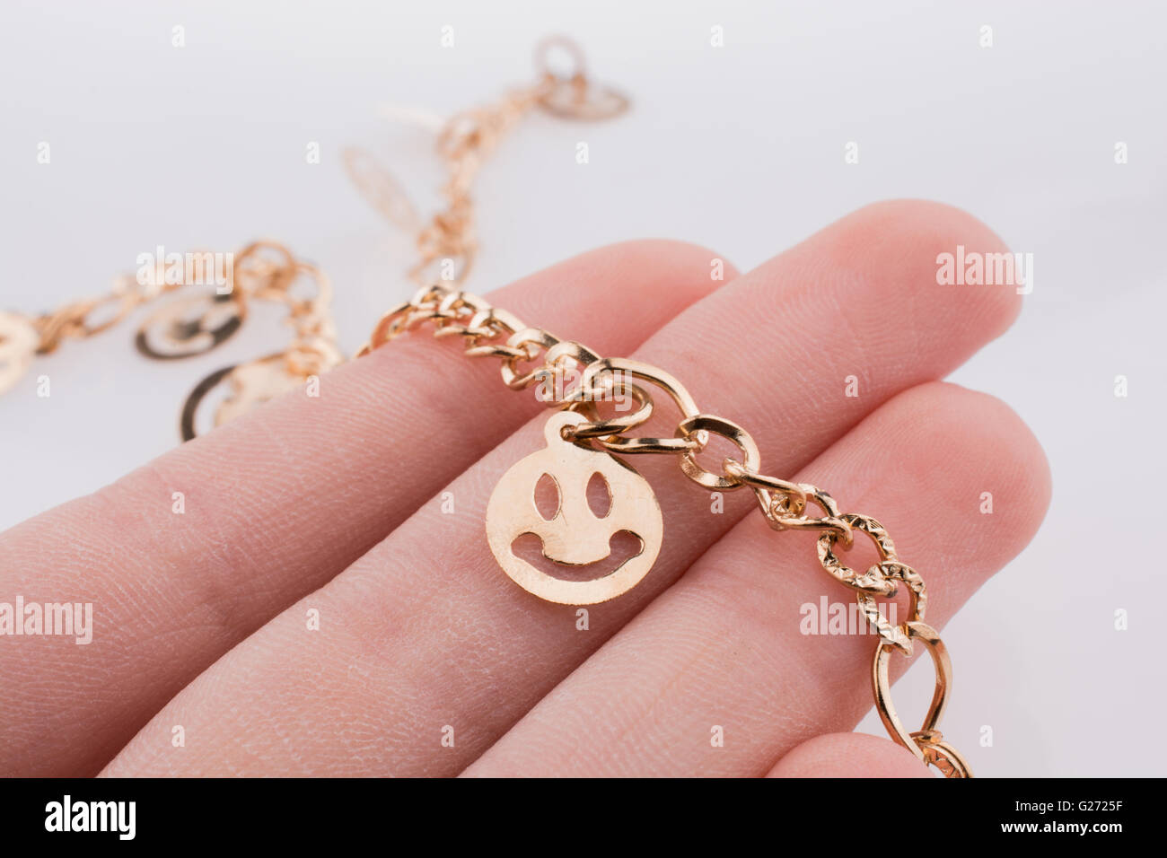 Golden color smileys arrayed on a chain in hand Stock Photo - Alamy