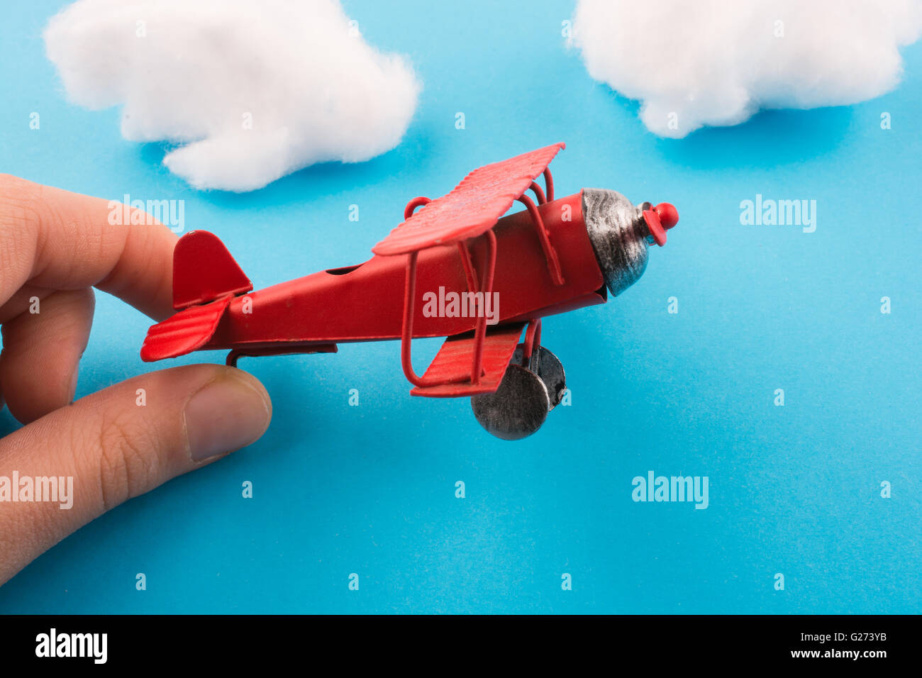 Retro styled red model airplane in hand, blue sky and clouds Stock ...