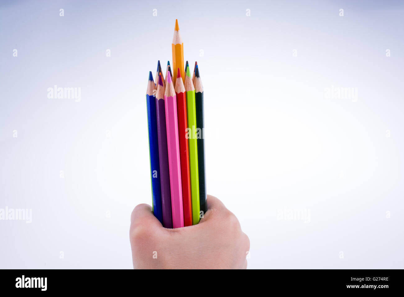Hand holding color pencils on a white background Stock Photo - Alamy