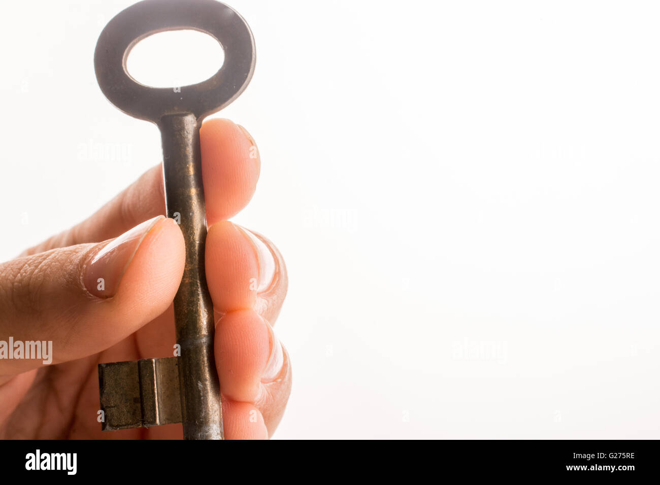 Hand holding a key on a white background Stock Photo - Alamy