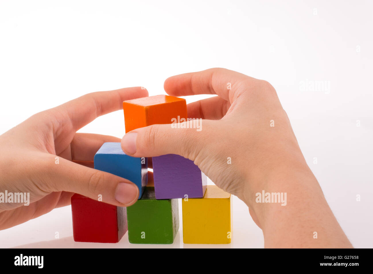 Hand playing with colorful cubes on a white background Stock Photo - Alamy