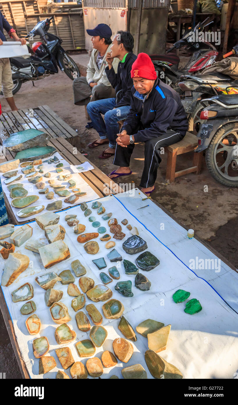 Seller with display of rough cut pieces of jade on sale at the roadside ...