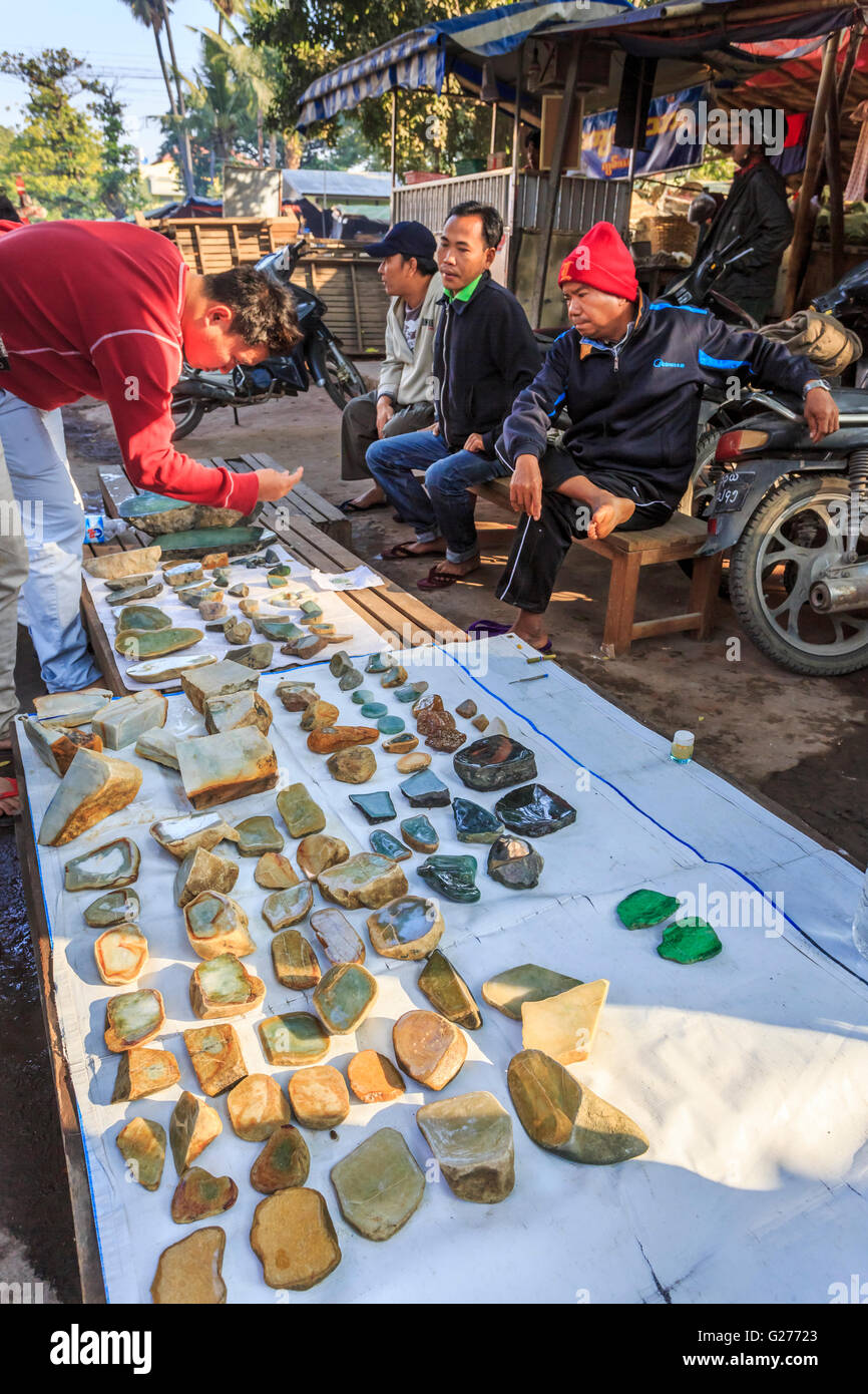 Seller with display of rough cut pieces of jade on sale at the roadside ...