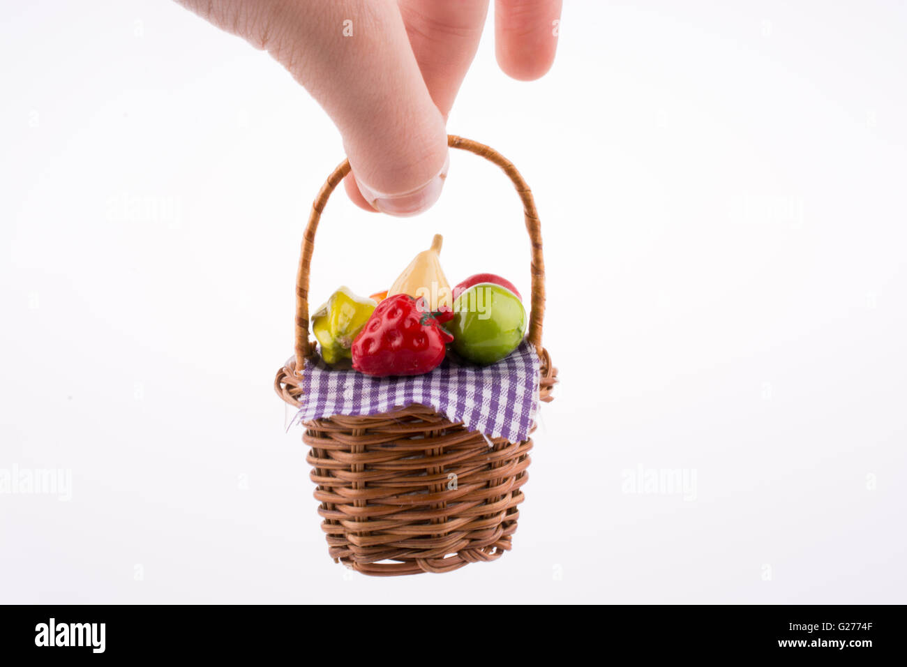 Hand holding a fruit basket on a white background Stock Photo - Alamy