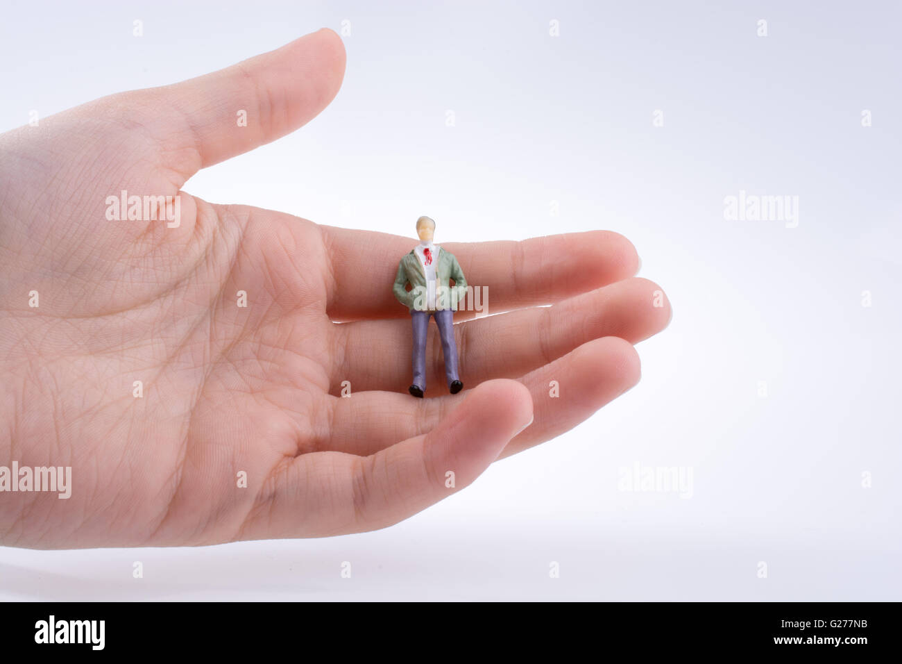 Hand holding a human figure on a white background Stock Photo - Alamy