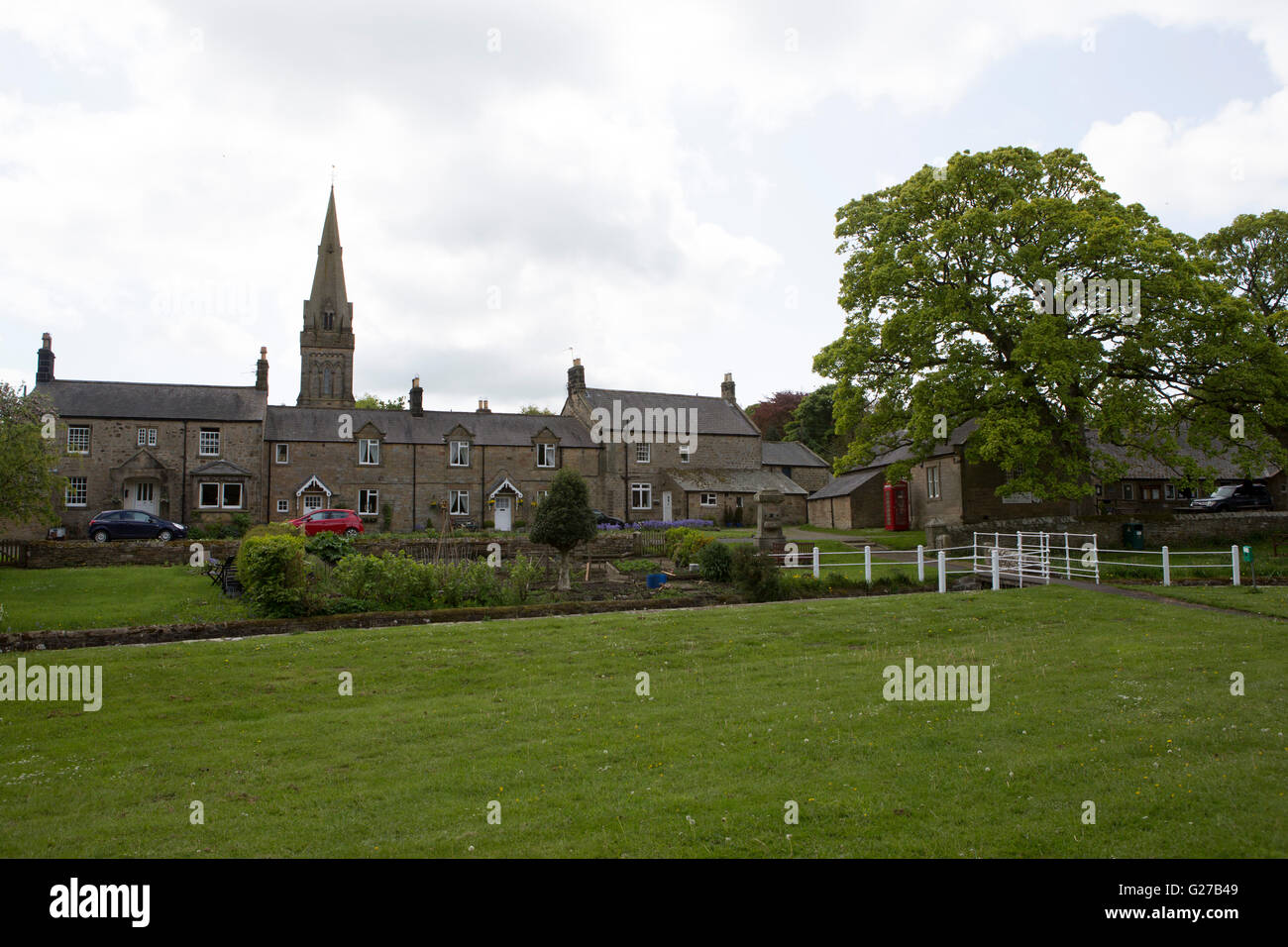 The village green in Matfen, England. A sunken stream runs past the ...