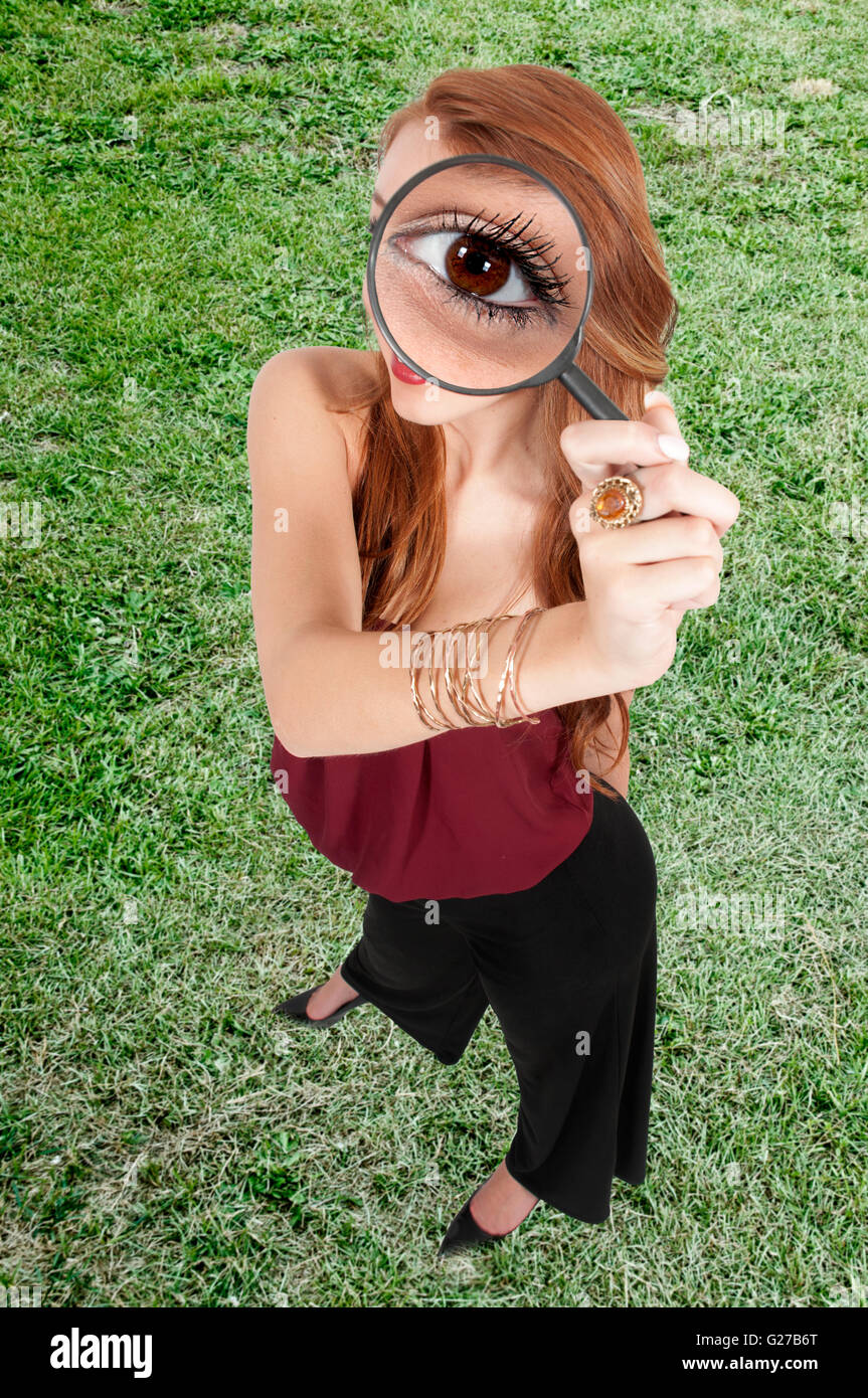 Beautiful curious woman looking through a magnifying glass Stock Photo ...