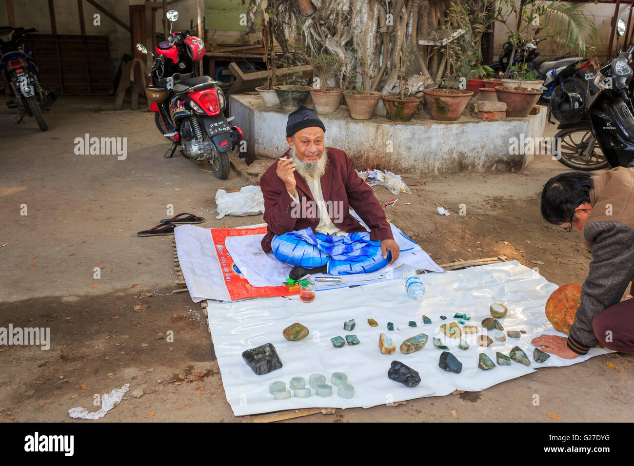 Bearded seller with display of rough cut pieces of jade on sale at the ...