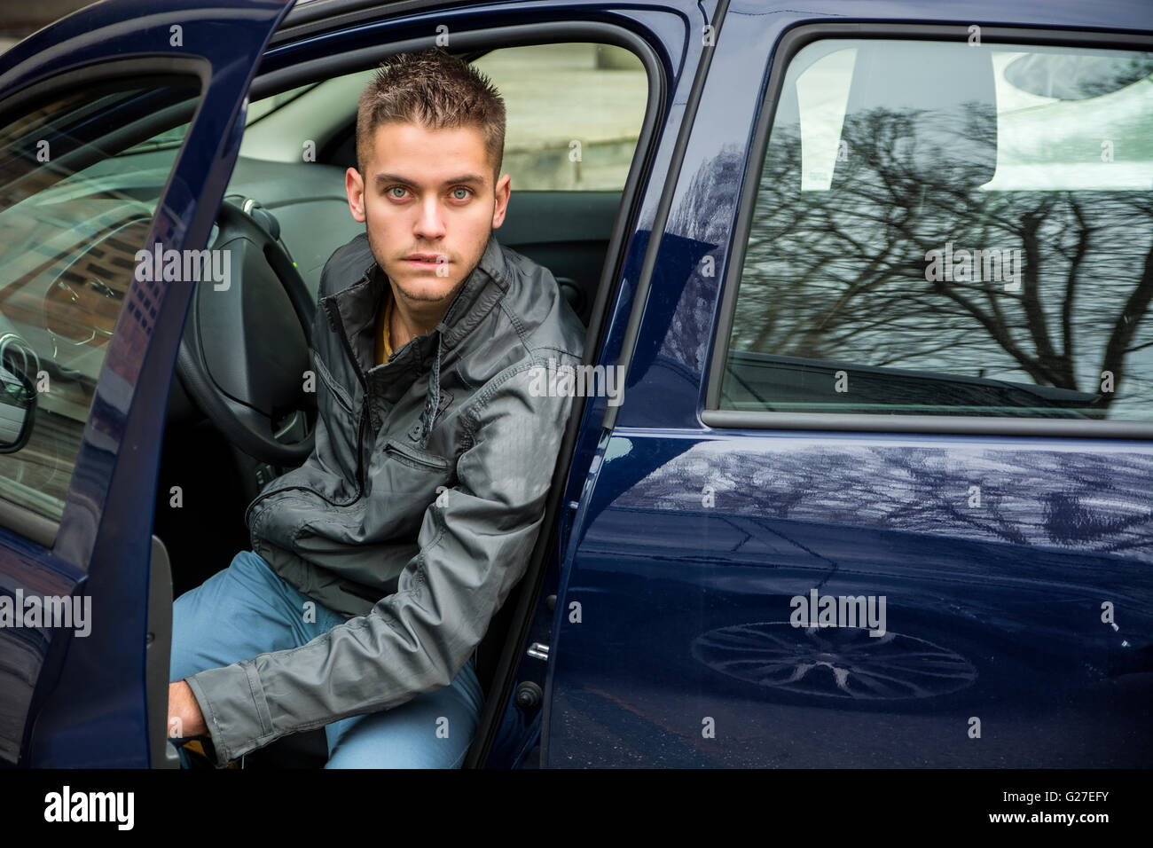 Handsome young man at wheel of his car while looking at camera Stock ...