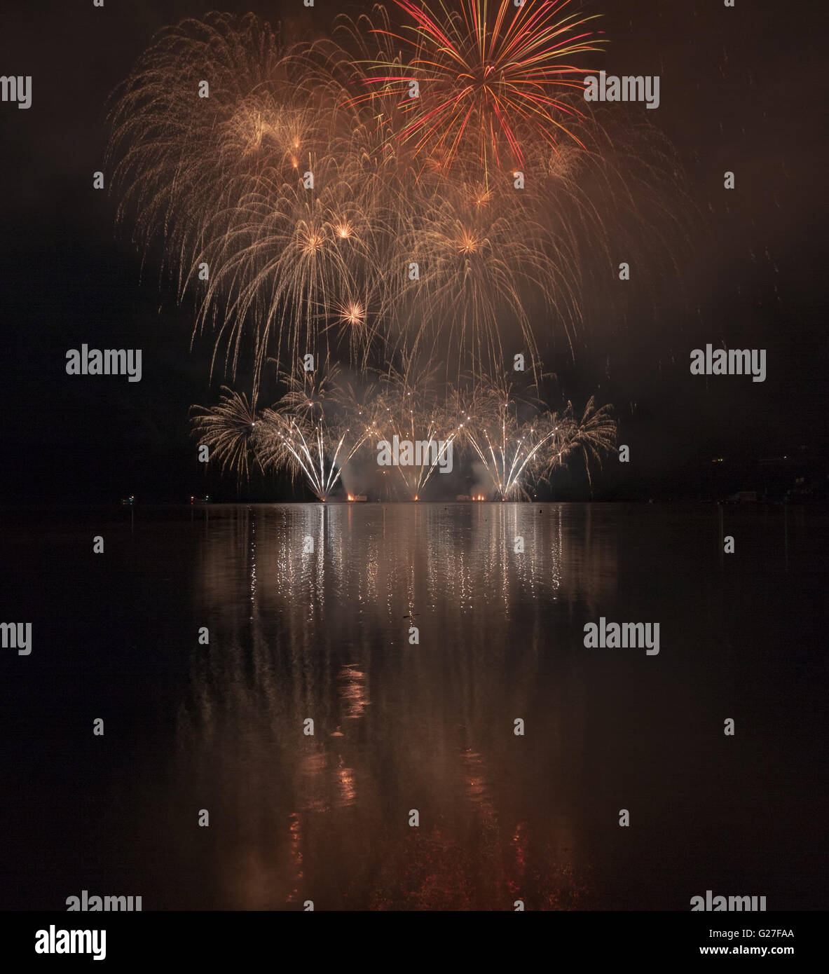 Colorful fireworks with reflection on lake and night sky in background ...