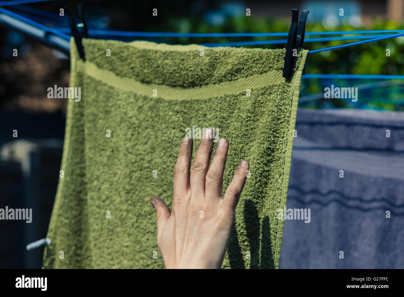 A dirty hand covered in muck is about to touch some clean laundry ...