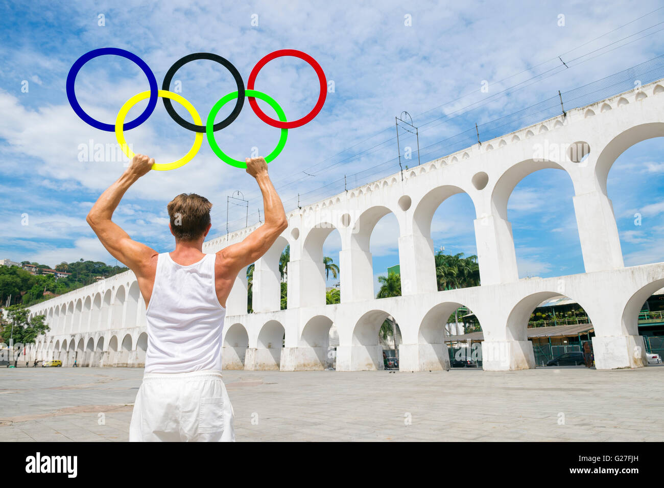 RIO DE JANEIRO - MARCH 29, 2016: Athlete holding Olympic rings stands ...