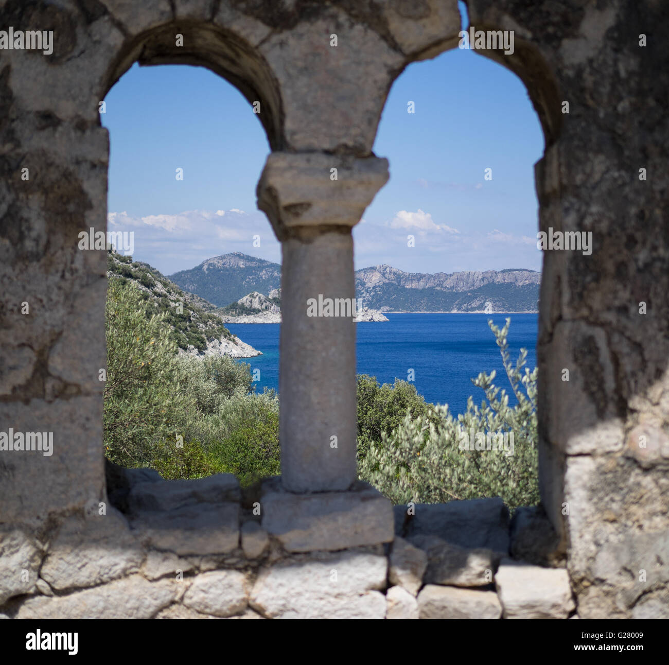 a view of Turkish coastline with blue sky and light clouds through arch ...