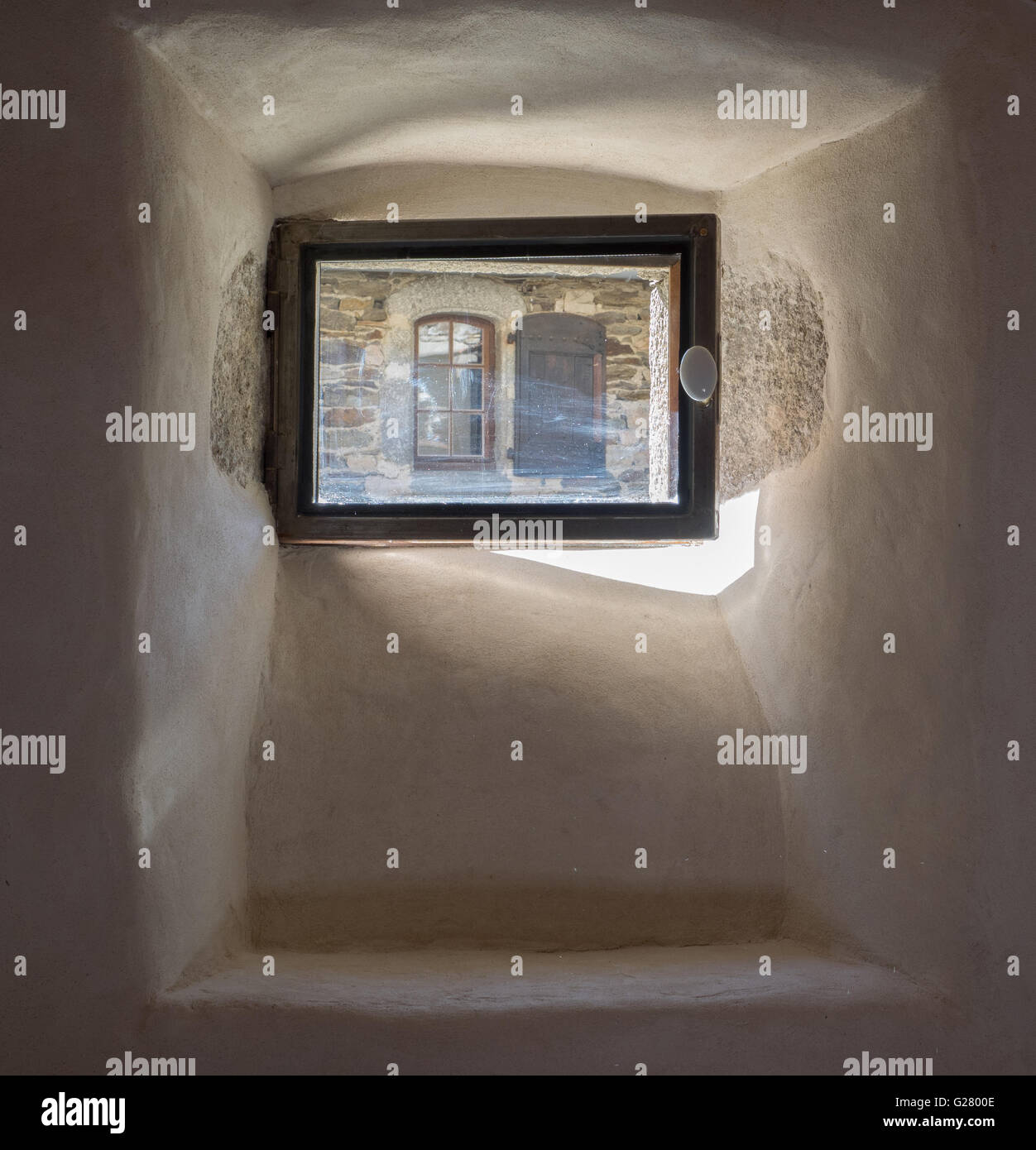 view of a wooden window and shutter through another window in a thinck ...