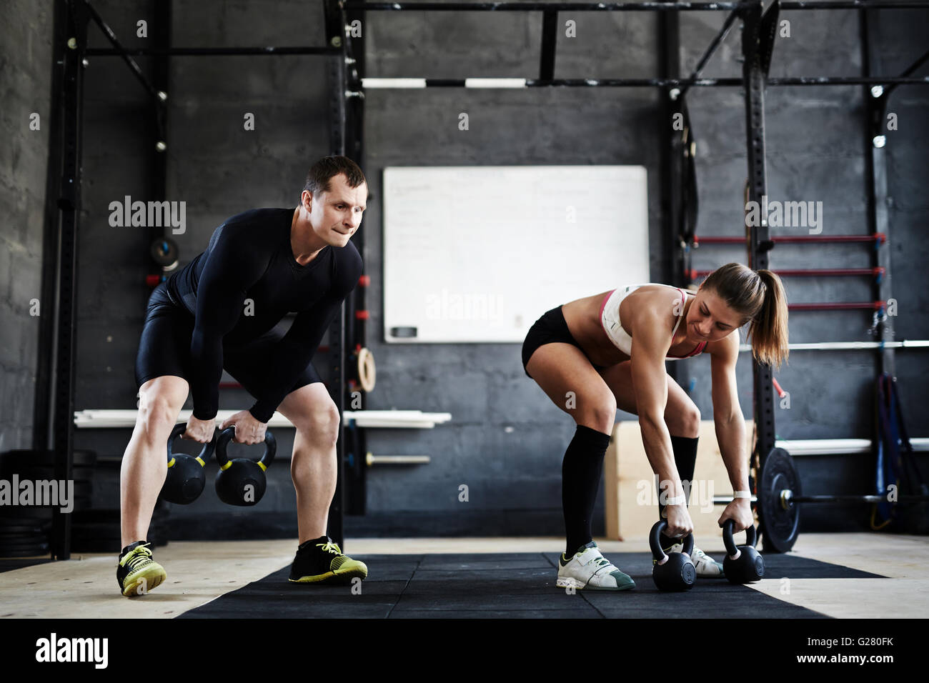 Two active people lifting heavy wods in gym Stock Photo - Alamy